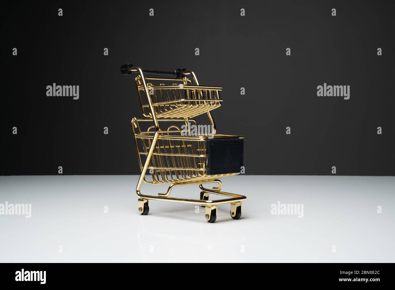 Small empty shopping cart or metal trolley in golden colour on top of ...