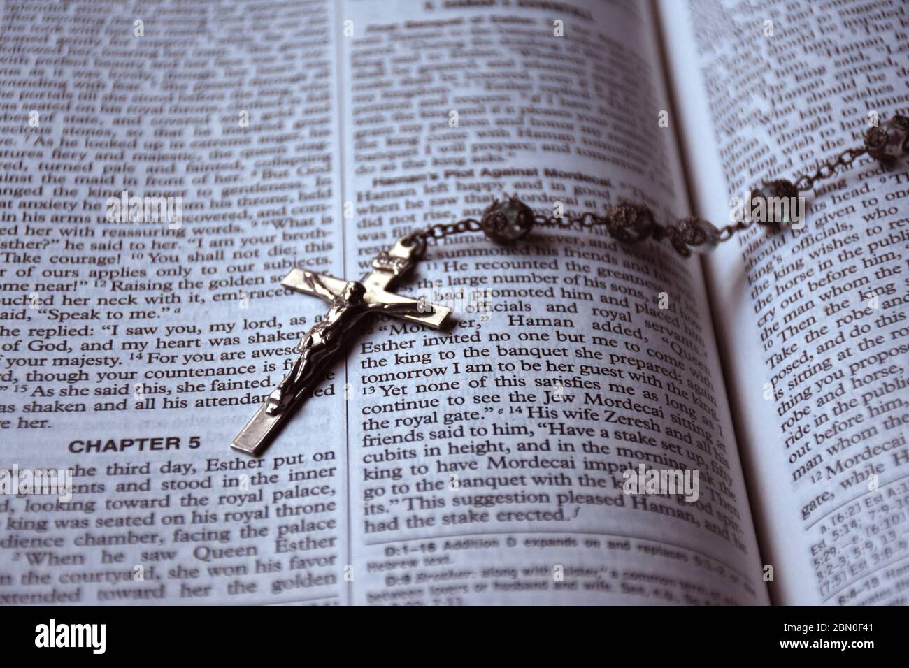 Crucifix with rosary beads laying across an open bible Stock Photo - Alamy