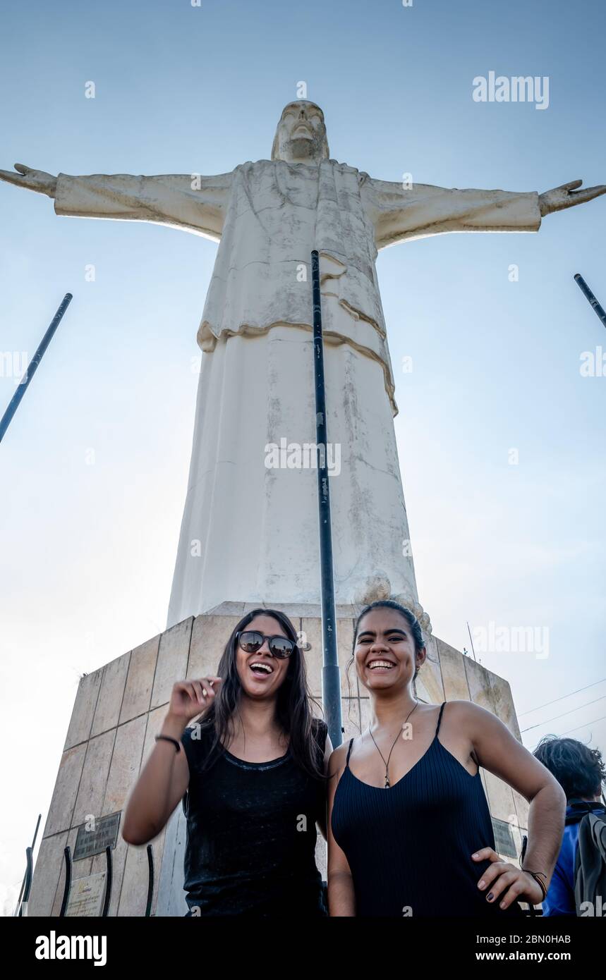 Two hispanic girls standing in front of the Cristo del Rey statue in ...
