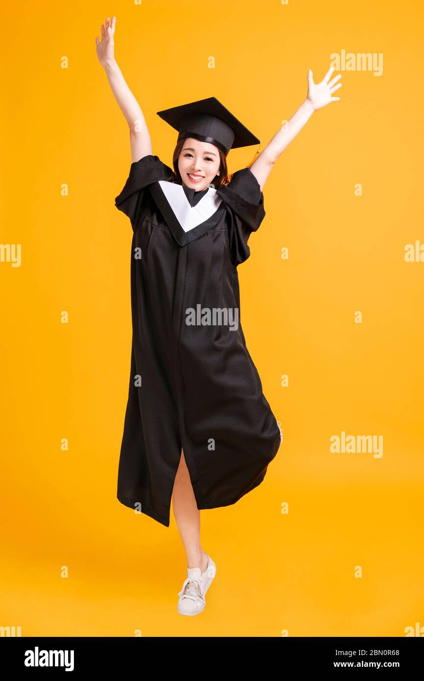 happy young woman in graduation gowns dancing for celebration Stock ...