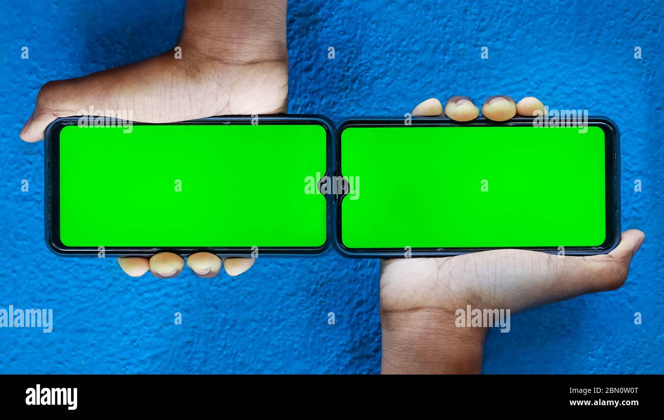 Double screen mobile smart phone in green color and boy holding on his ...