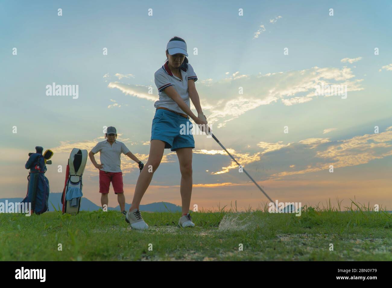 Couple in action of playing golf together Stock Photo - Alamy