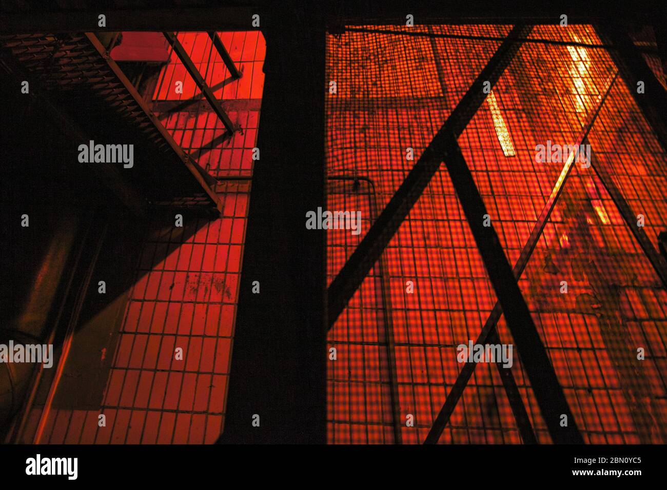 Reworked photo of metal panels. Red light. Luminous grid structure ...