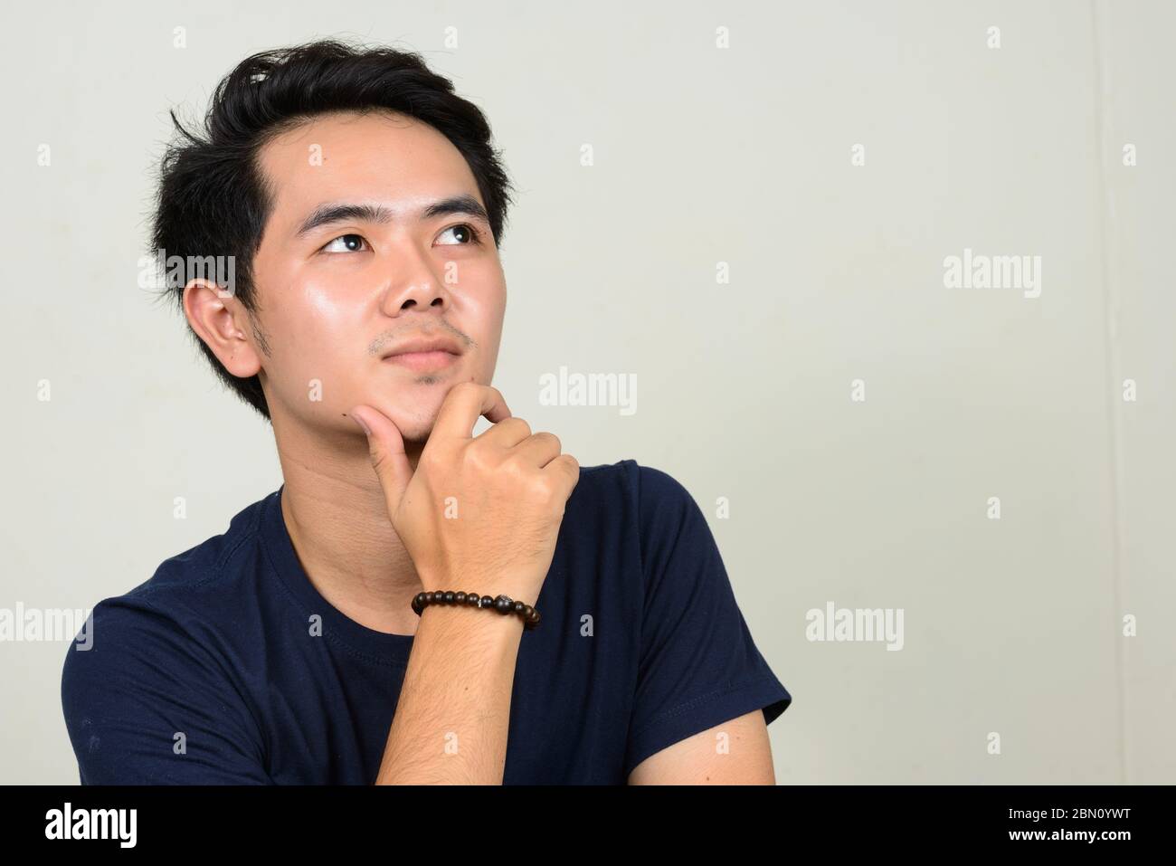 Portrait of young Asian man thinking and looking up Stock Photo - Alamy