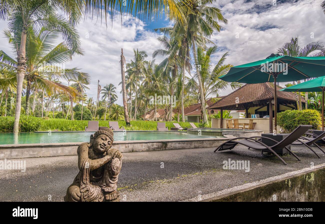 Balinese Statue by pool at resort in Indonesia Stock Photo - Alamy