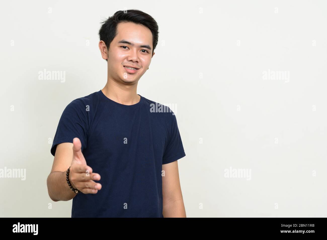Portrait of happy young Asian man giving handshake Stock Photo - Alamy