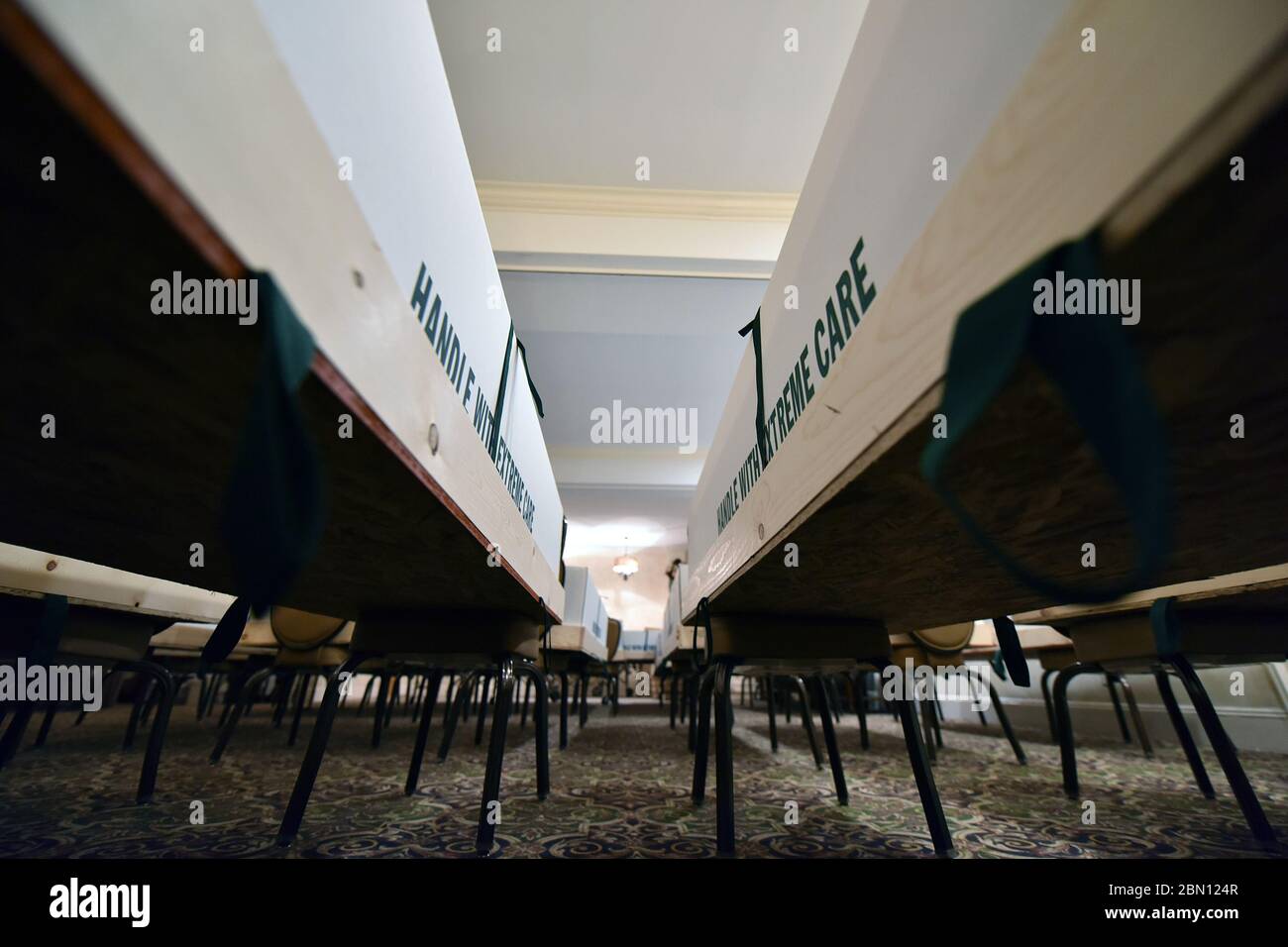 Bodies in cremation funeral caskets are lined up in rows sitting on ...