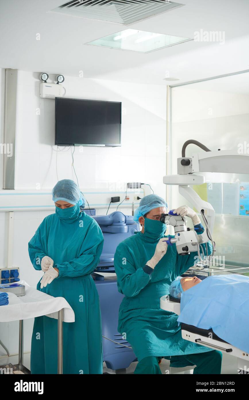 Team of surgeons getting ready for eye surgery or vision restoration ...