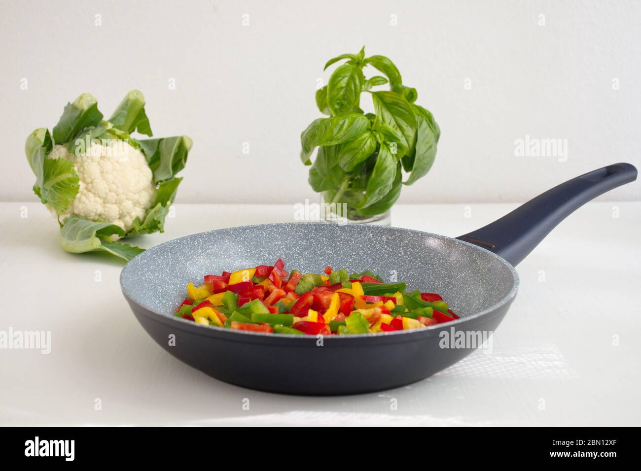 Frying pan and colorful vegetables on white background Stock Photo - Alamy