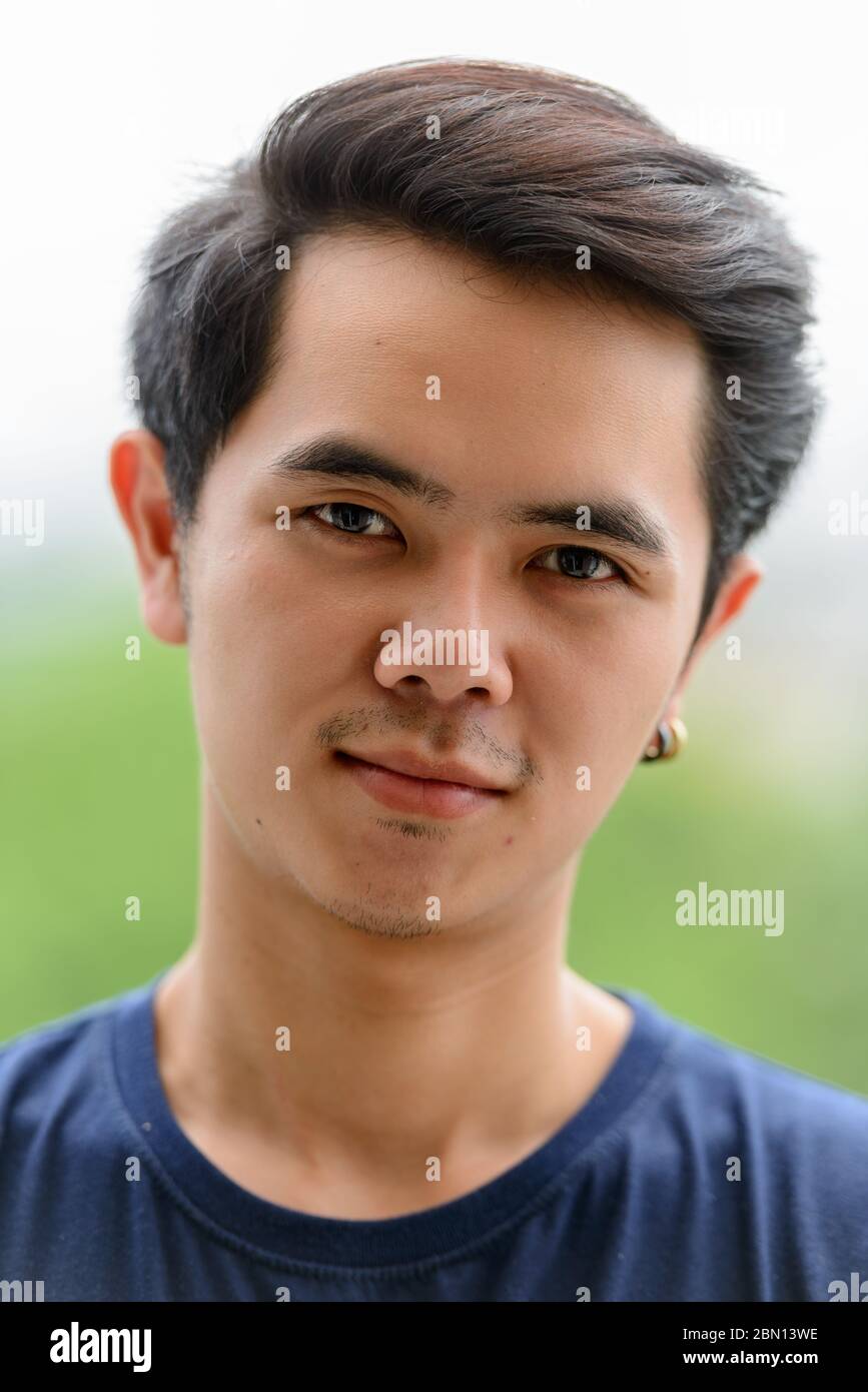 Face of young Asian man looking at camera outdoors Stock Photo - Alamy
