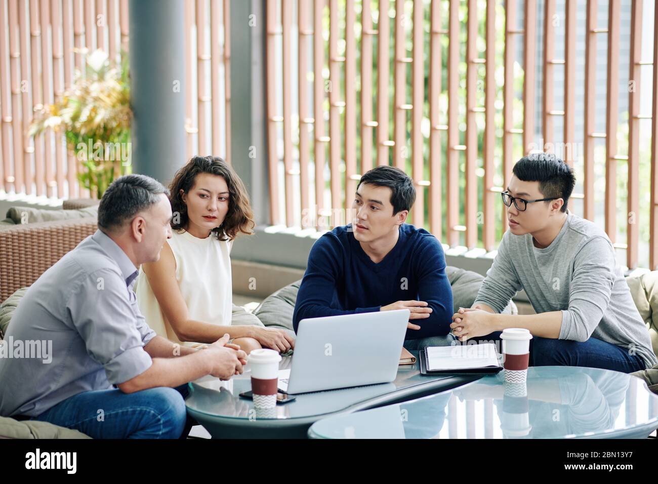 Group of serious business people discussing plan of project development ...