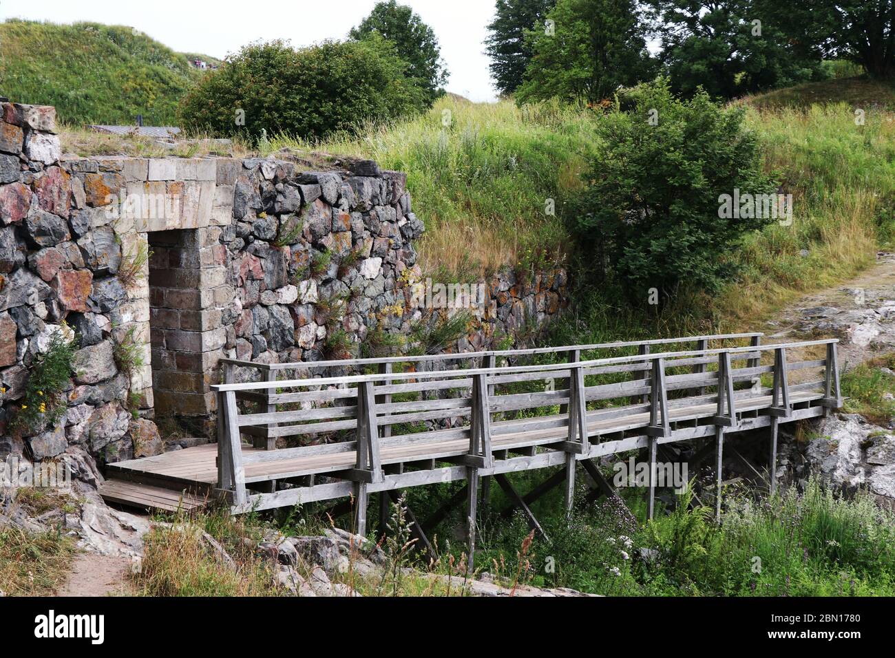 Small Wooden Bridge and Stone Brick Wall Stock Photo - Alamy
