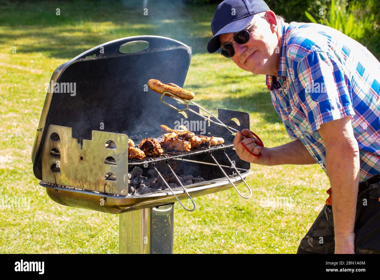 Hand holding cooking tongs hi-res stock photography and images - Alamy