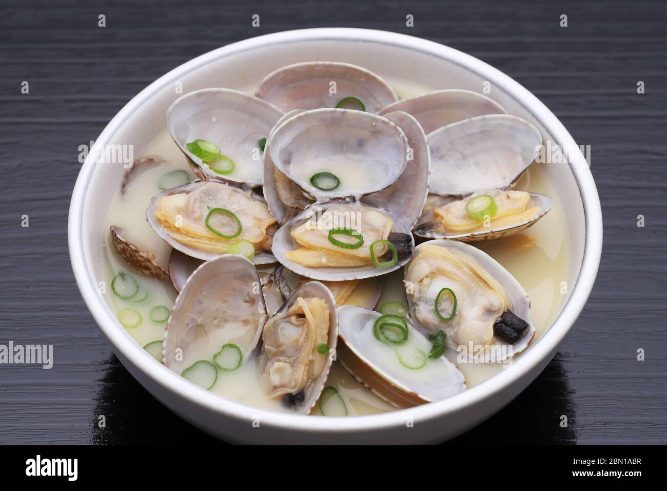 Japanese traditional cuisine, Sake steamed clams, Sakamushi, on table ...