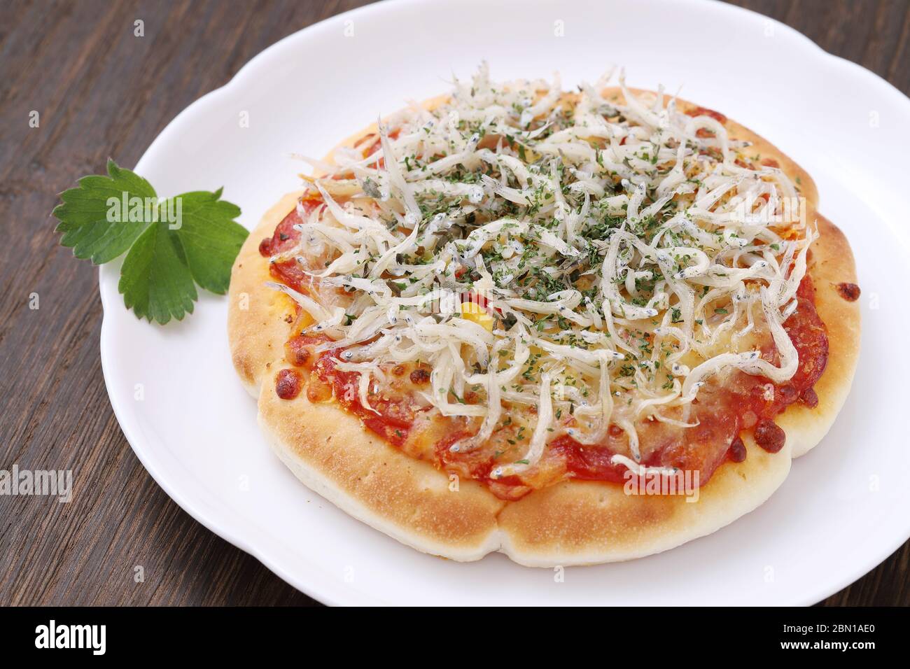 small fish shirasu pizza on a plate with wooden table Stock Photo - Alamy