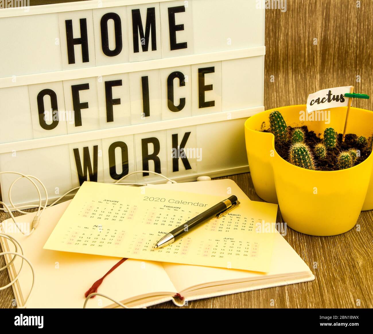 lightbox with text HOME OFFICE WORK with notebook pen and cactus ...