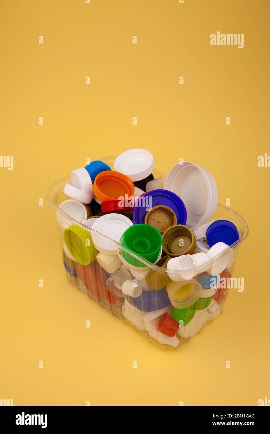 Sort plastic bottle caps. Recycling. Zero waste. Yellow background with ...