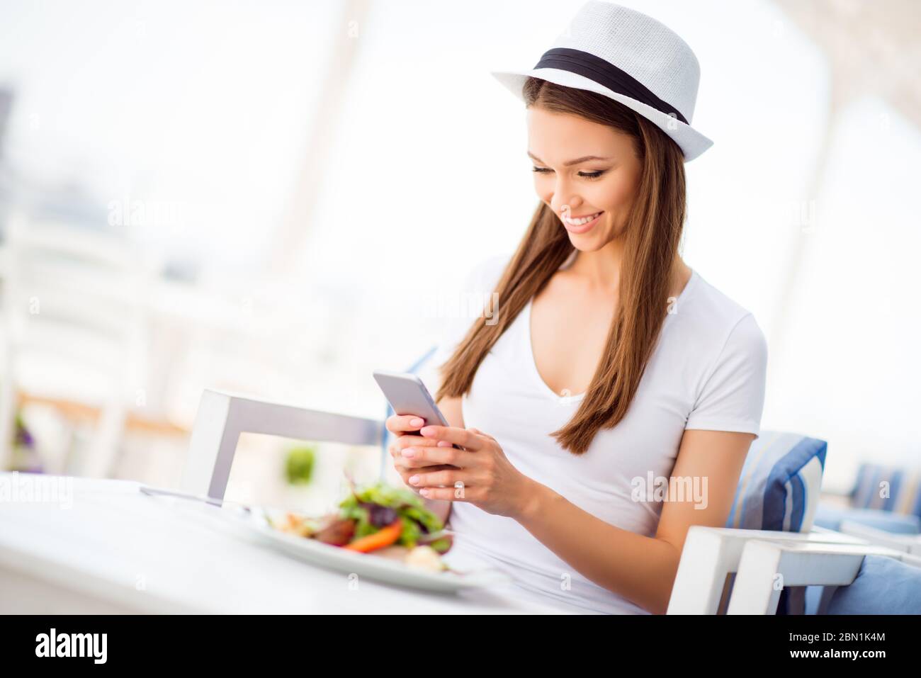 Young cute lady is browsing on her pda while having a salad in the ...