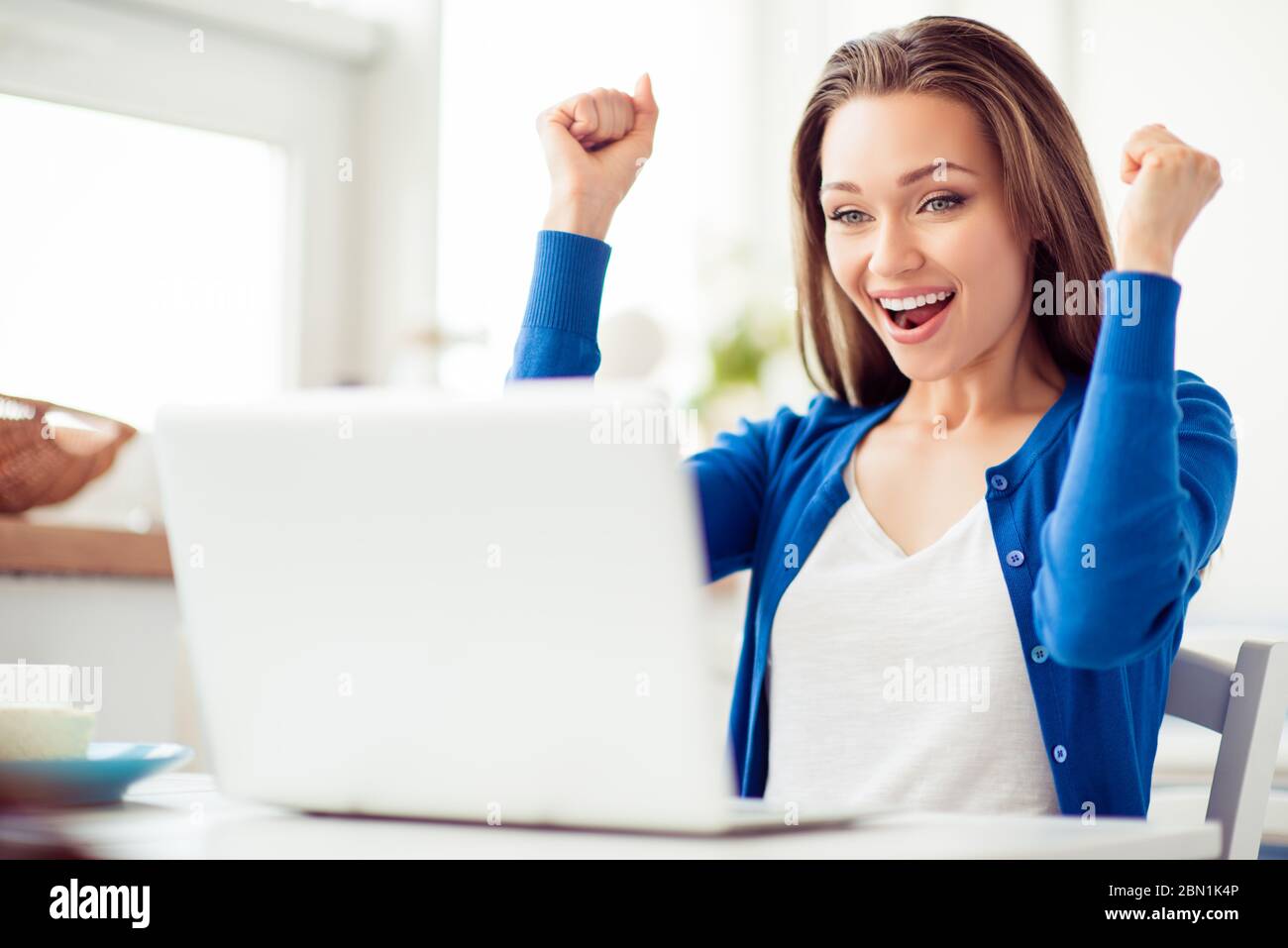 Oh yeah! Happy amazed young girl is celebrating. She is excited and ...