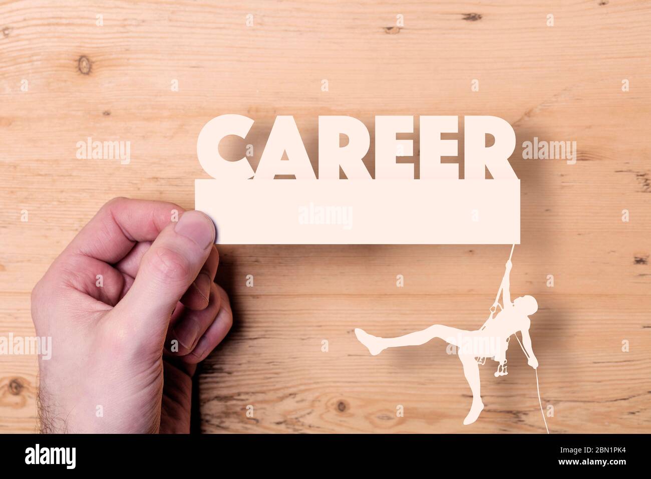 A paper cutout of a climber reaching the word Career. Business concept ...