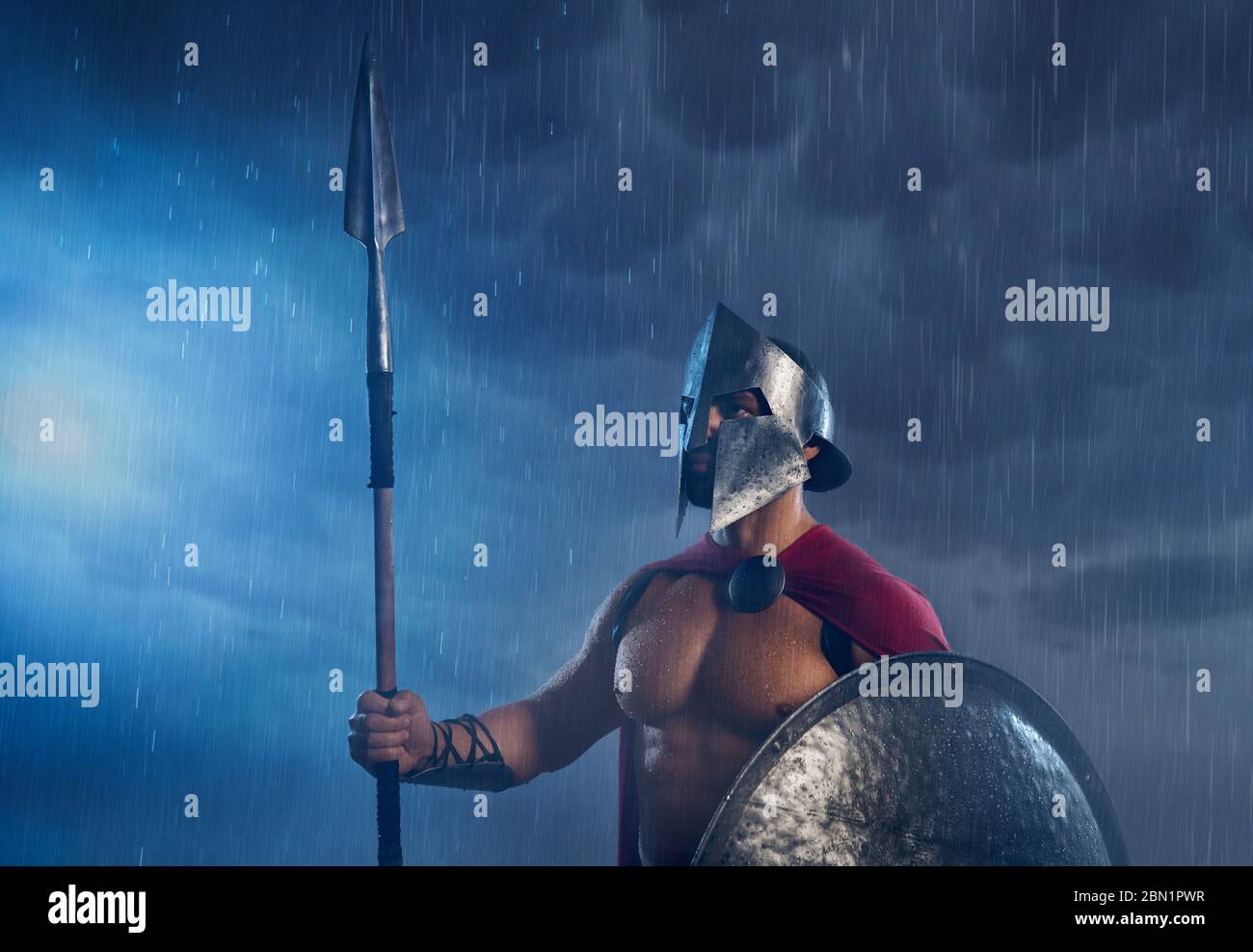 Portrait of spartan warrior standing outdoors with spear and shield in ...