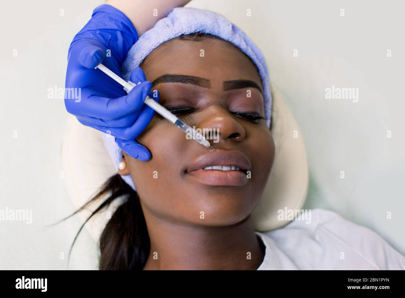 Beautiful young African woman gets cosmetic injection on her lips ...