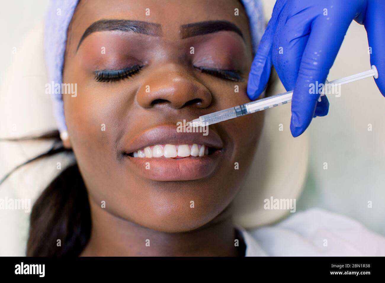 cropped shot of young african american woman getting beauty injection ...