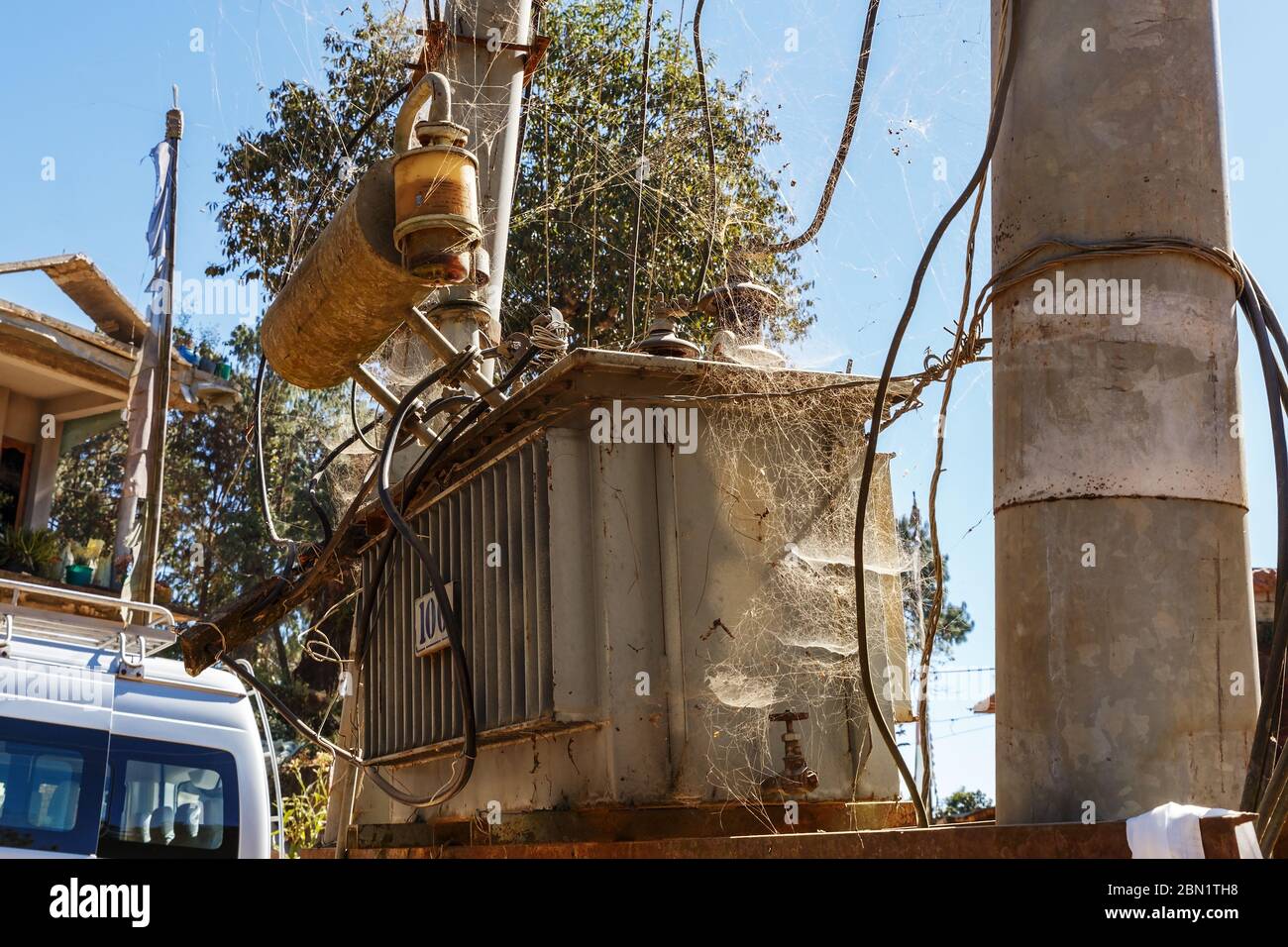 Electric transformer on a post in Nepal. Transformer tangled in spider ...