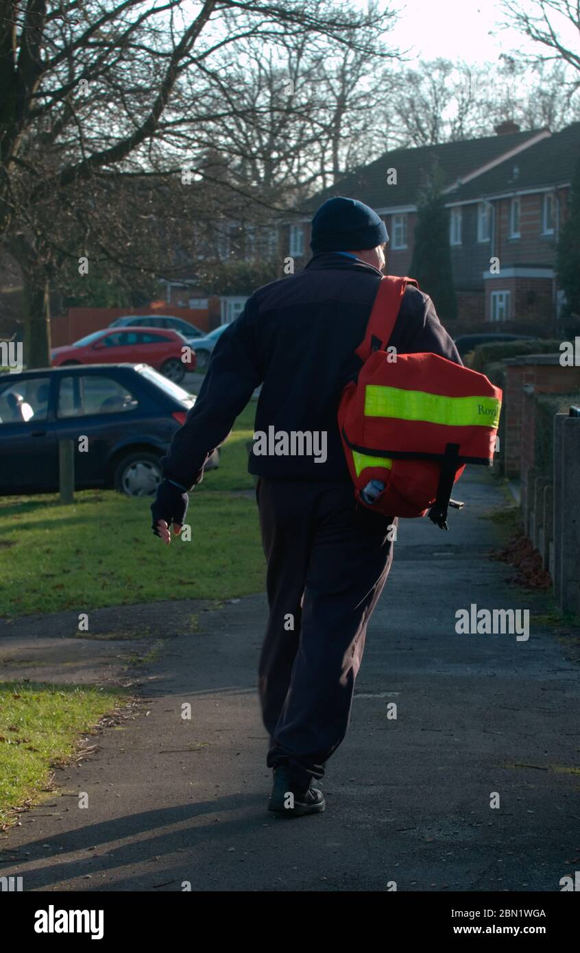 Postman (approaching his 60s) walking briskly as he works, Reading; UK ...