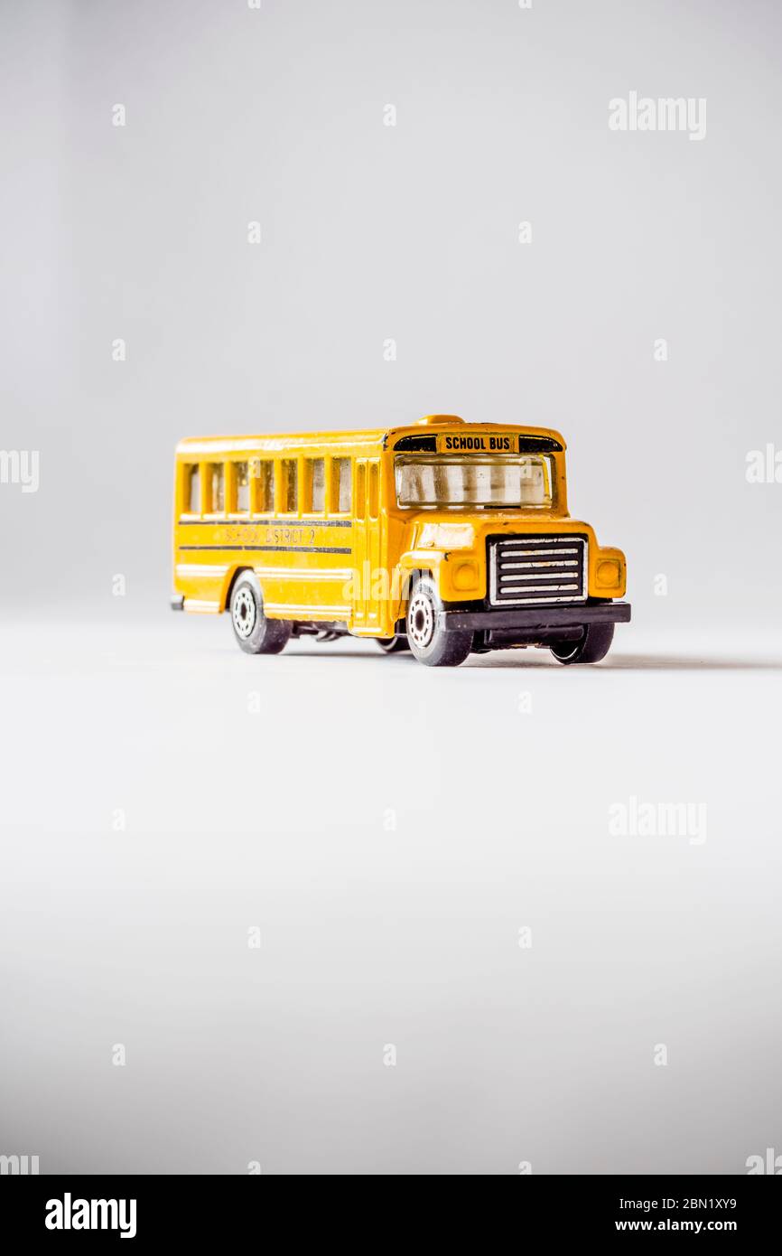 A battered and worn old toy American School Bus on a white background ...