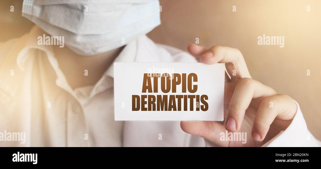 Atopic dermatitis on a card held by Doctor's hand. Doctor wears ...
