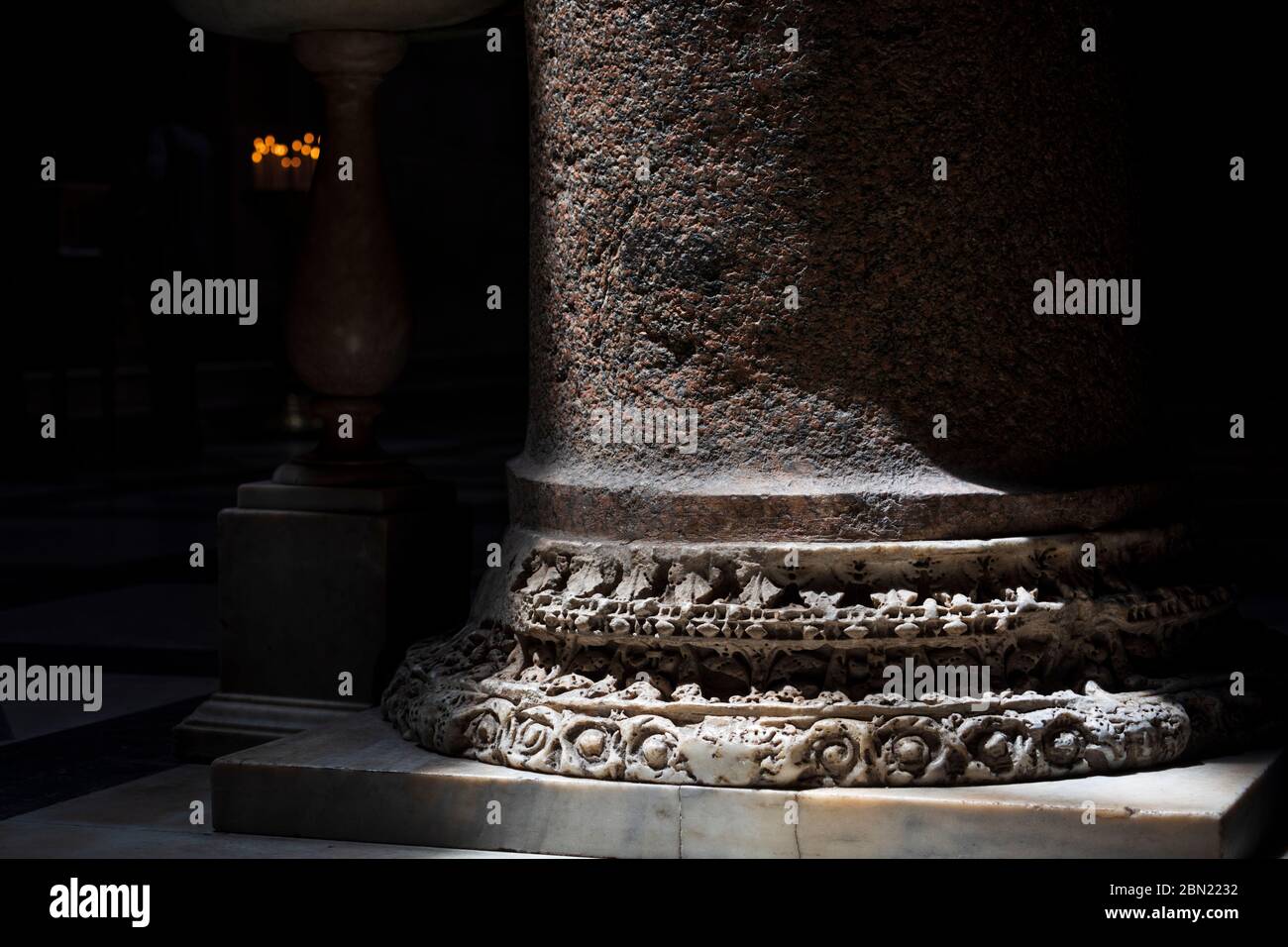 Interior view of stone columns and glowing candlelight inside the ...