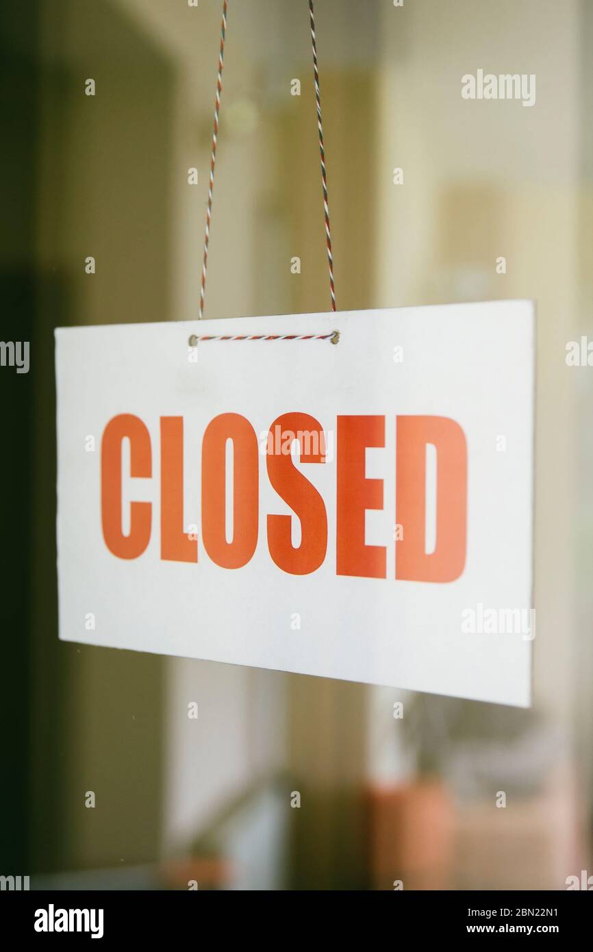Closed sign board hanging on the glass door of cafe or small store ...