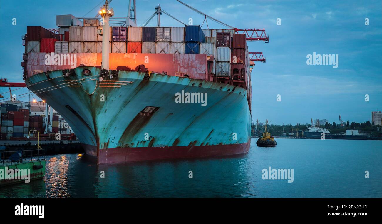 Container cargo ship load in the seaport at dusk. Logistics and ...