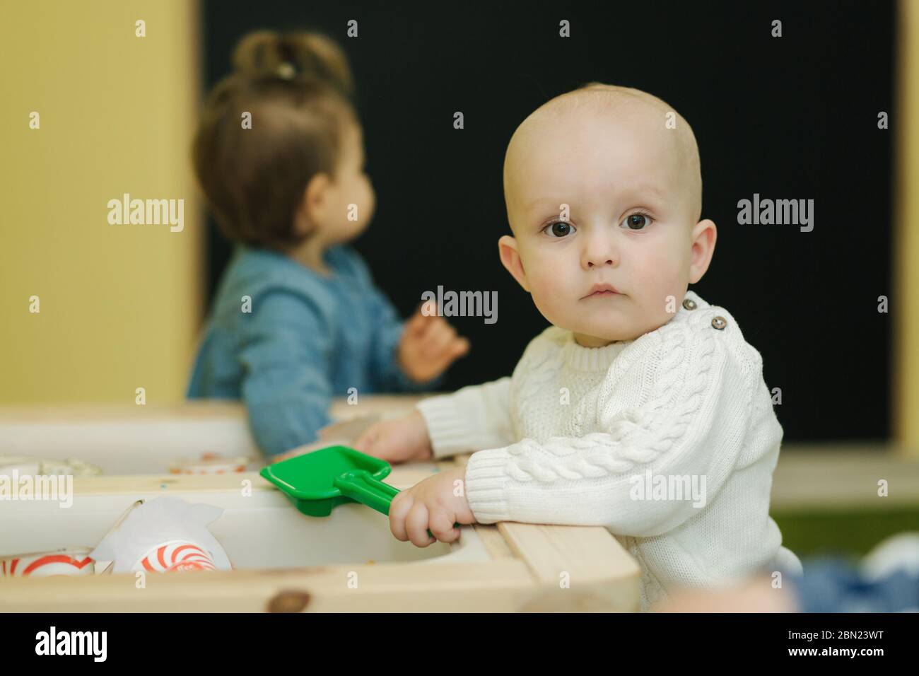 Cute kids one year old play together in nursery. Adorable little ...