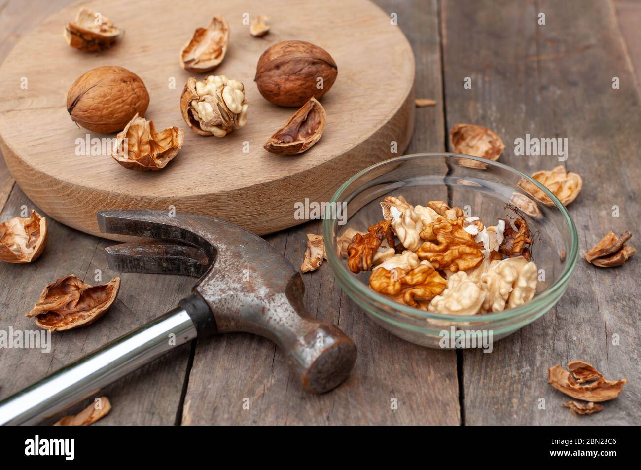 Cracked walnuts and hammer Stock Photo - Alamy