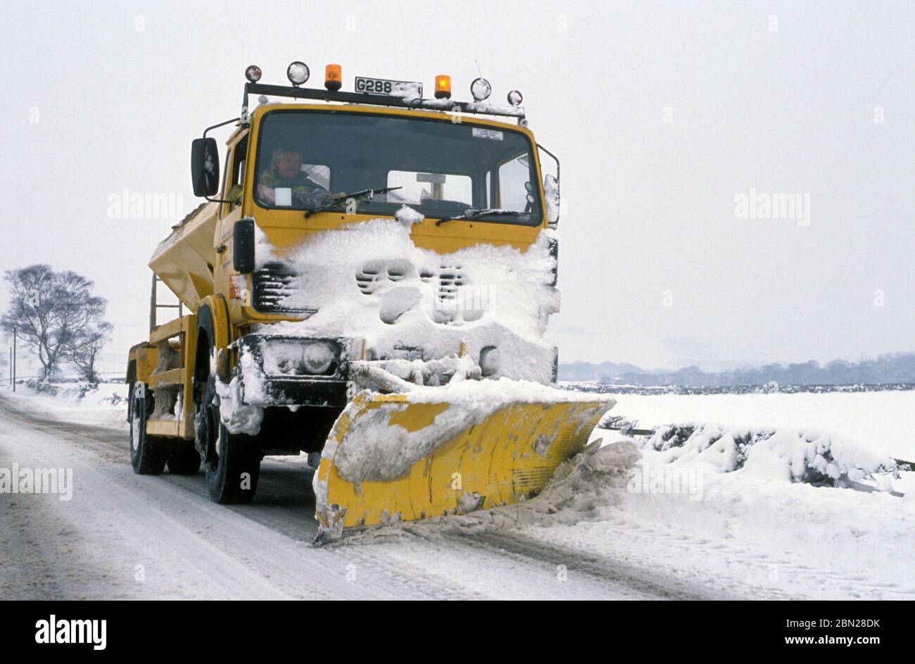 Snowplough gritter clearing snow on country road Co Durham UK Stock ...
