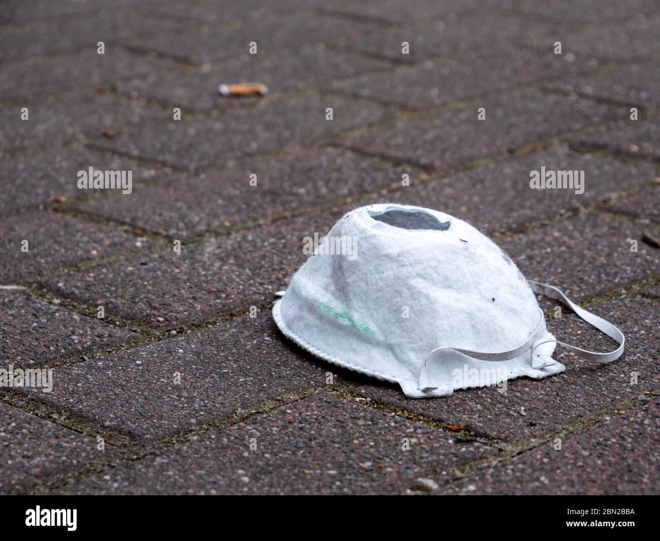 Used face mask on the street Stock Photo - Alamy