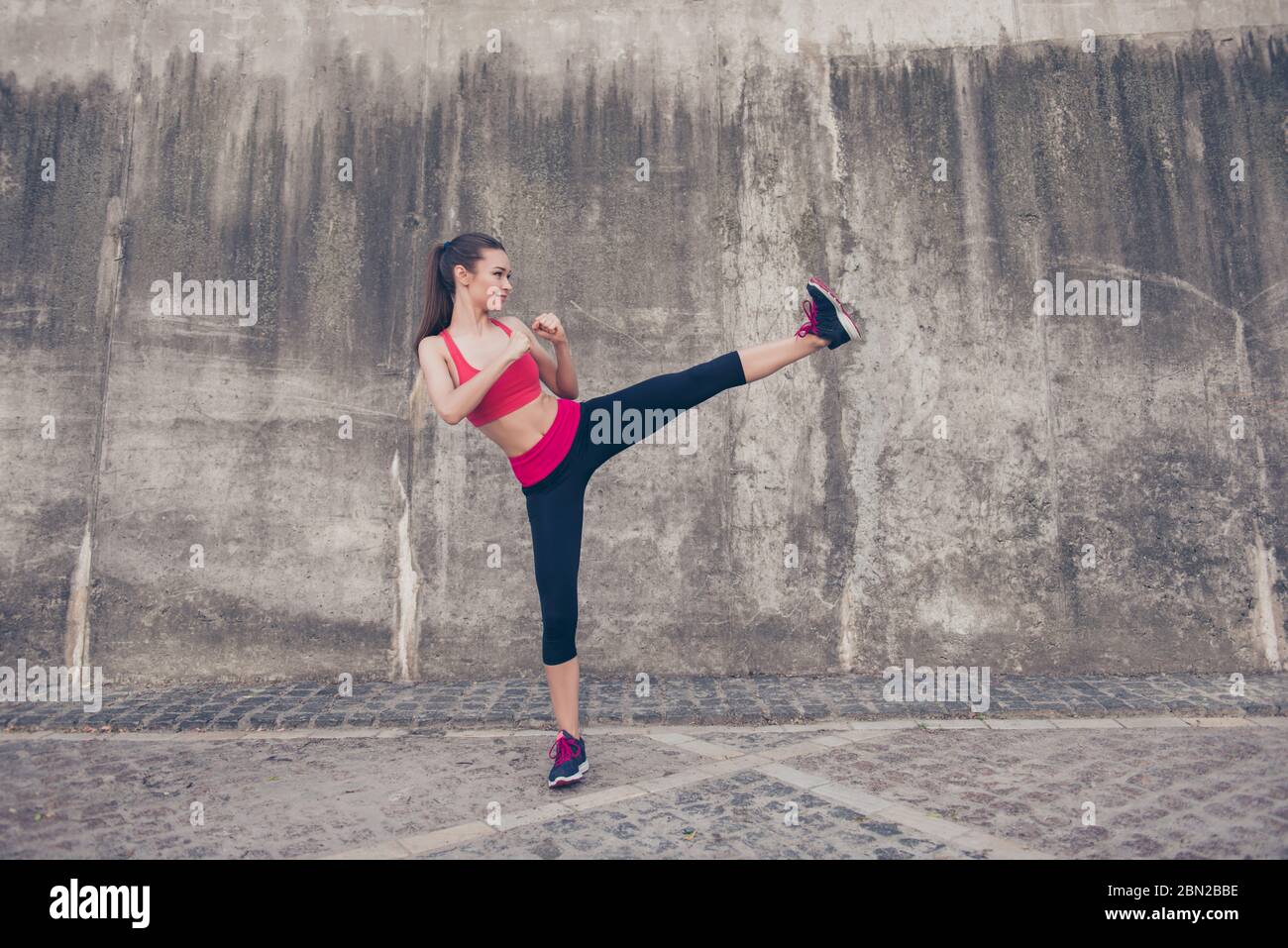 Side profile photo of attractive brunette, kickboxing high kick ...