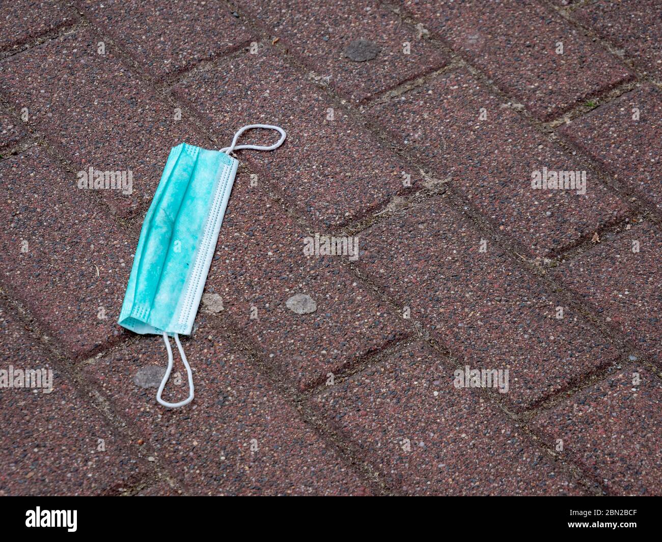 Used face mask thrown away after mask requirement Stock Photo - Alamy