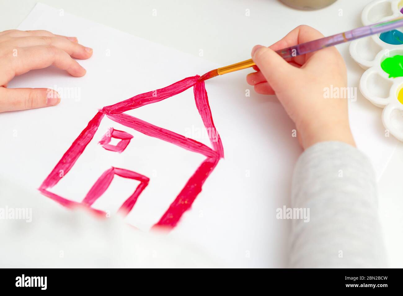 Child is drawing house roof with watercolors on white paper Stock Photo ...