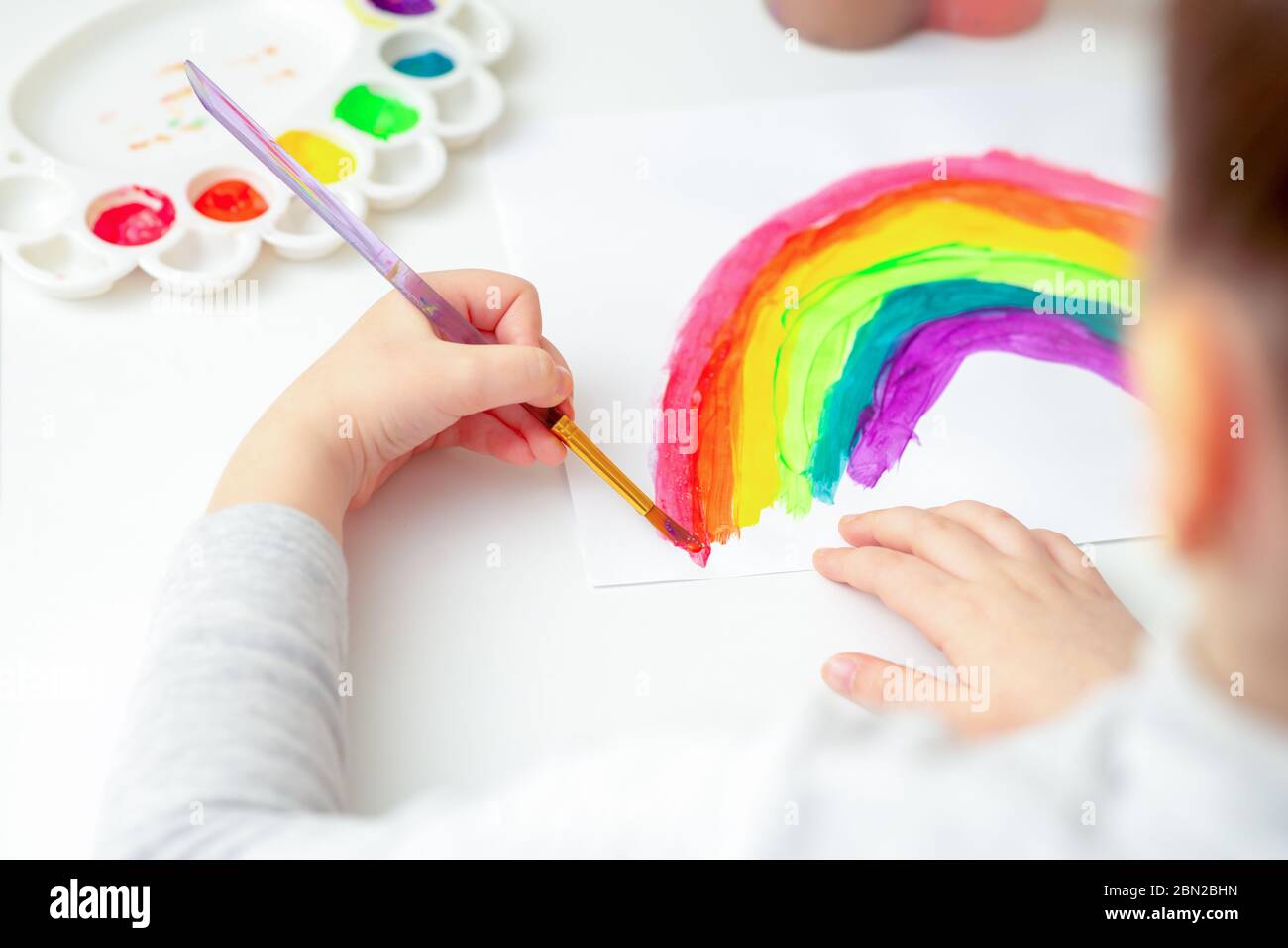 Painted rainbow by the hands of a child with watercolors on a white ...