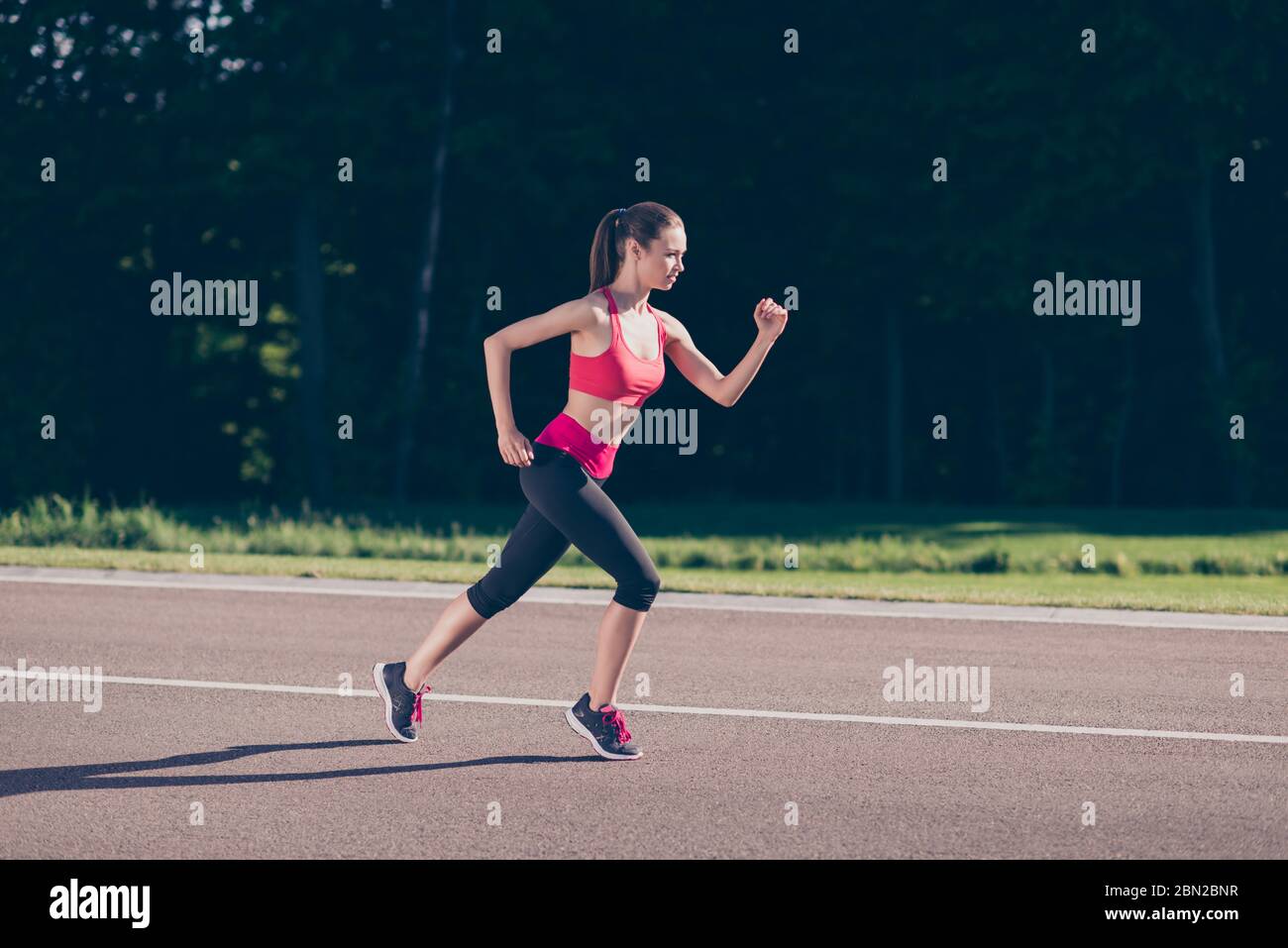 Young lady trainer running outdoors, training for marathon run ...