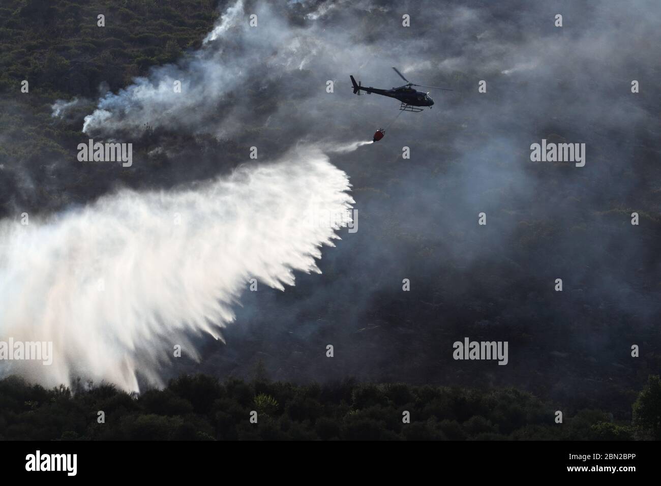 a fire helicopter engaged in fire fighting a forest fire Stock Photo ...