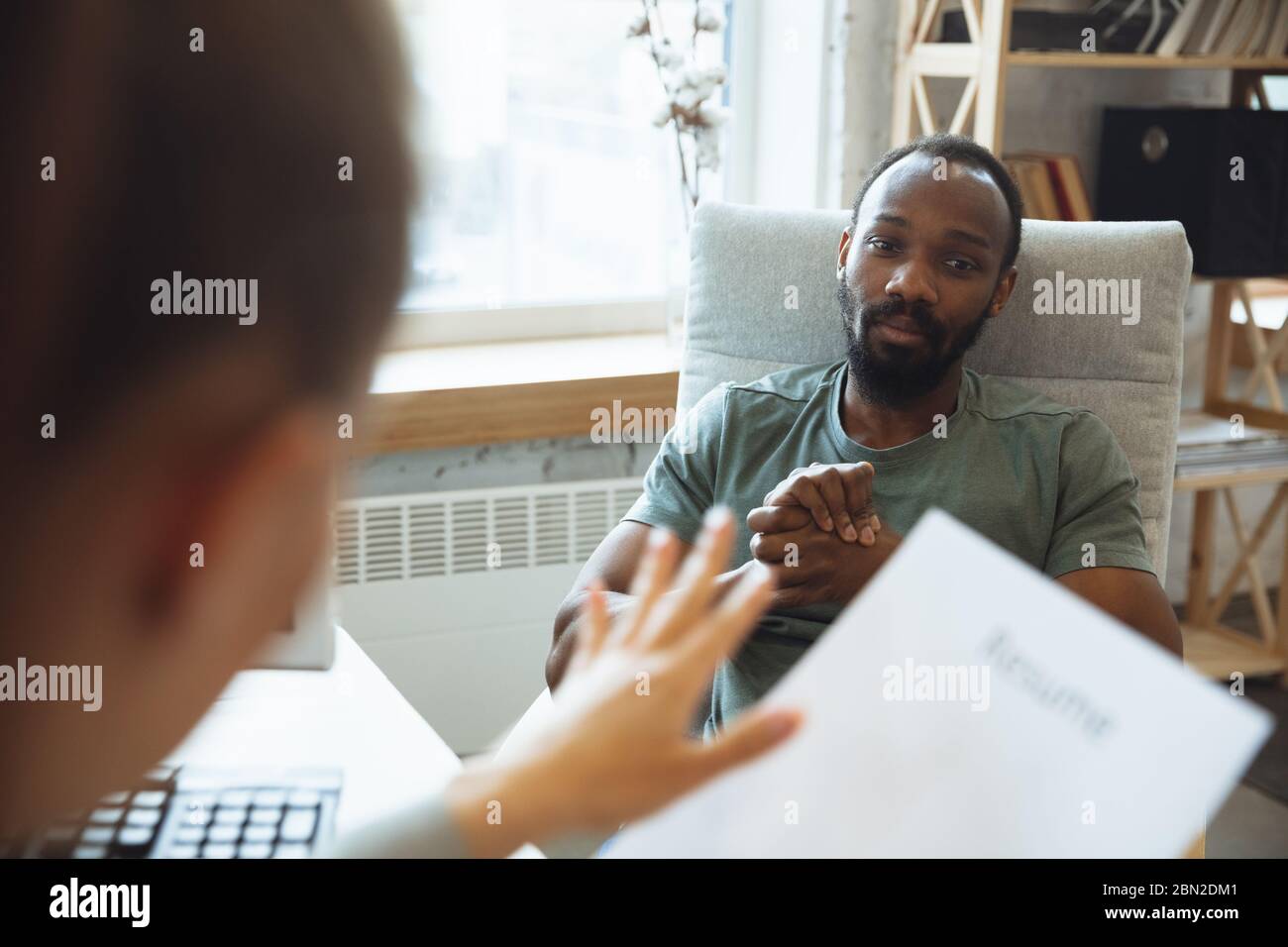 Young man sitting in office during the job interview with female ...