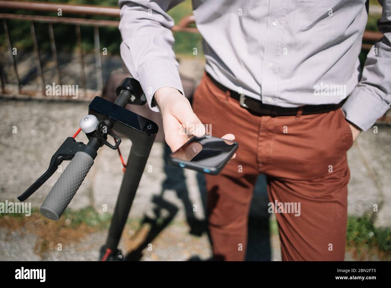 Cropped man holding smartphone while standing. Male hand holding black ...