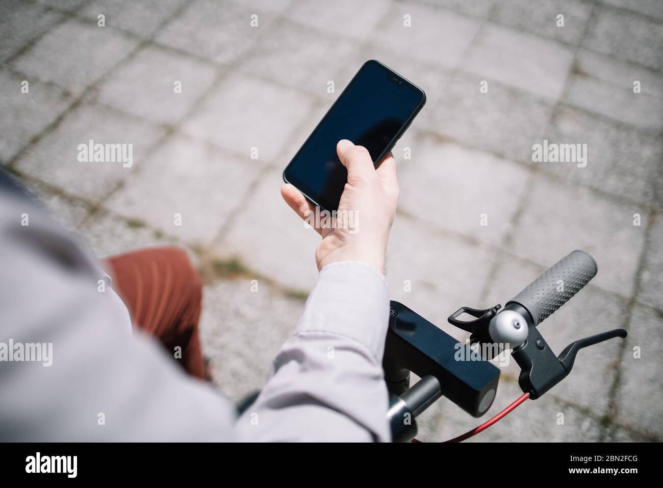Man's hand holding black smartphone with blank screen. Cropped guy ...