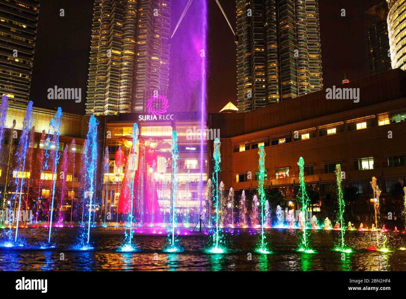 Multi-colored dancing fountains near the twin towers of Petronas in ...