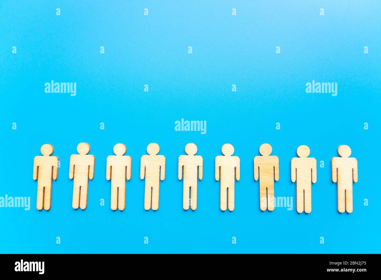 Wooden figures on blue background as a symbol of team building ...
