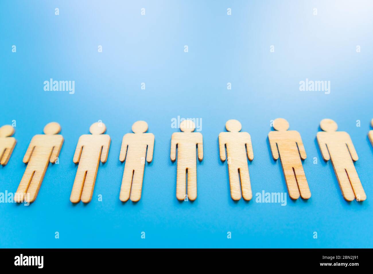 Wooden figures on blue background as a symbol of team building ...